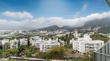 Zona residencial com edifícios modernos, céu claro e uma montanha ao fundo.