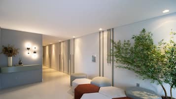 Um interior moderno com balcão de recepção, área de estar e uma planta.