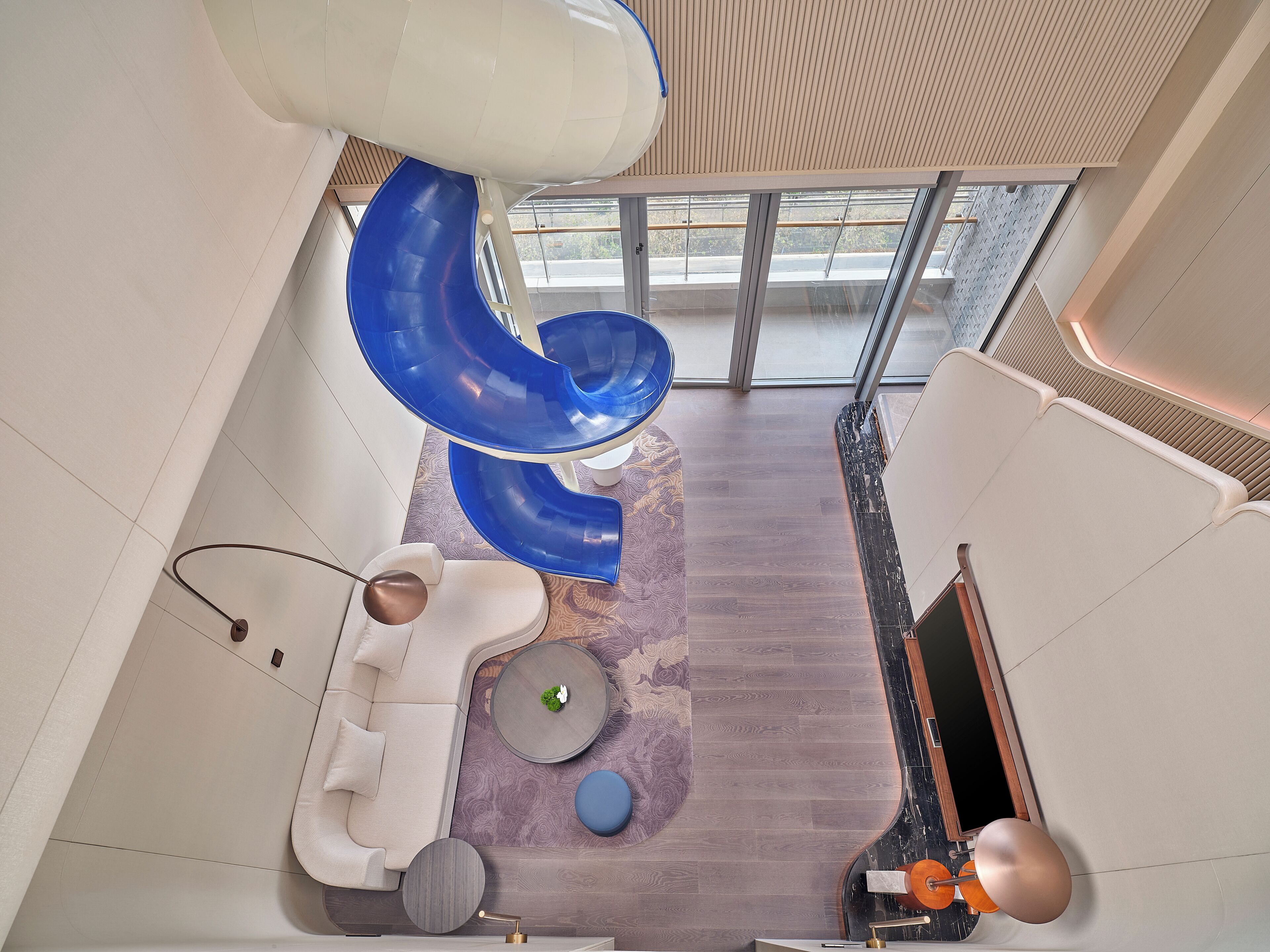 Interior moderno com um escorregador em espiral, um sofá, uma mesa de centro e um piano.