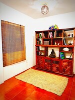 Um quarto com estante de madeira, tapete tecido e luminária no teto.
