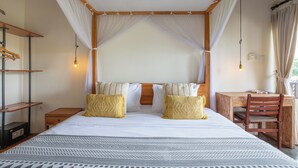 Quarto com cama de dossel, uma escrivaninha de madeira e uma cadeira.