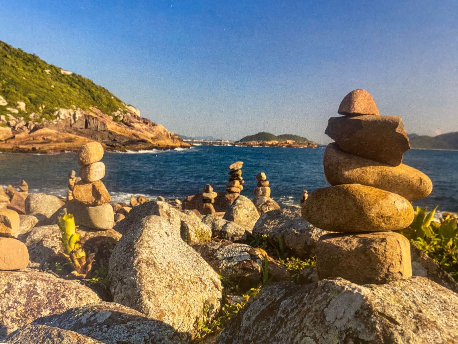 Paisagem costeira com pilhas de rochas e vista para o mar.