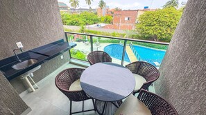 Varanda com piscina, móveis de exterior e vista para edifícios.