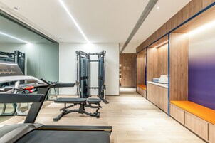 Uma academia moderna com equipamentos de ginástica, esteira e um painel com armários.