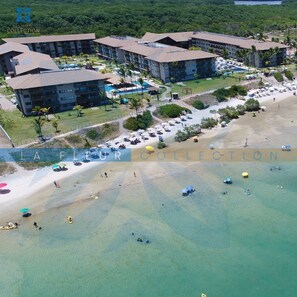 Na praia, praia de areia branca, espreguiçadeiras, guarda-sóis de praia 