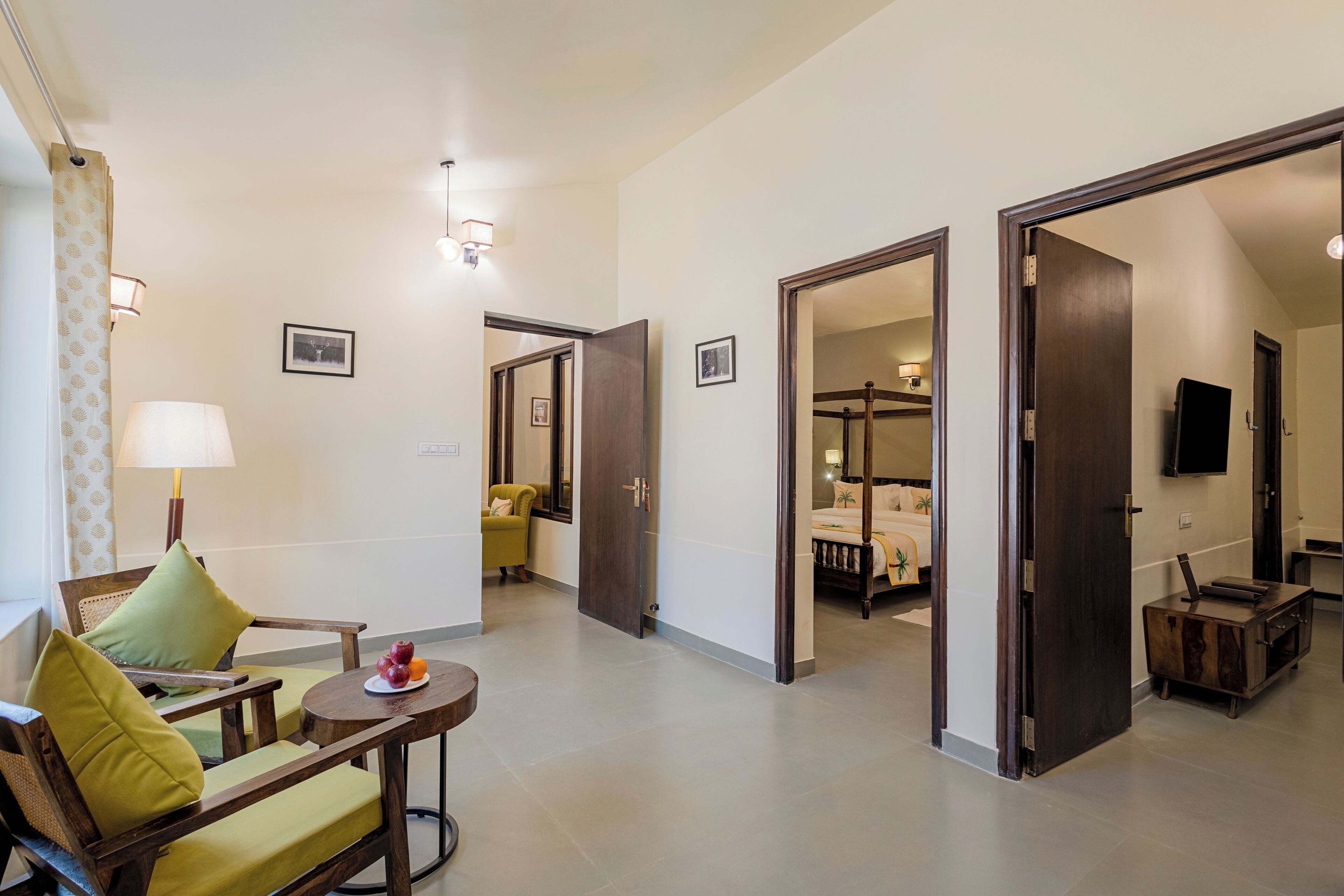 Quarto de hotel com área de refeições, cama e televisão.