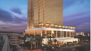 Um hotel moderno e alto, com um letreiro chamativo 'TRUMP' no topo.