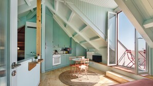 Quarto moderno no estilo loft com um amplo claraboia, uma área de estar aconchegante e uma kitchenette.