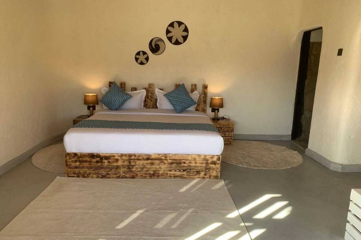 Quarto com uma cama, duas mesas de cabeceira e decoração de parede.
