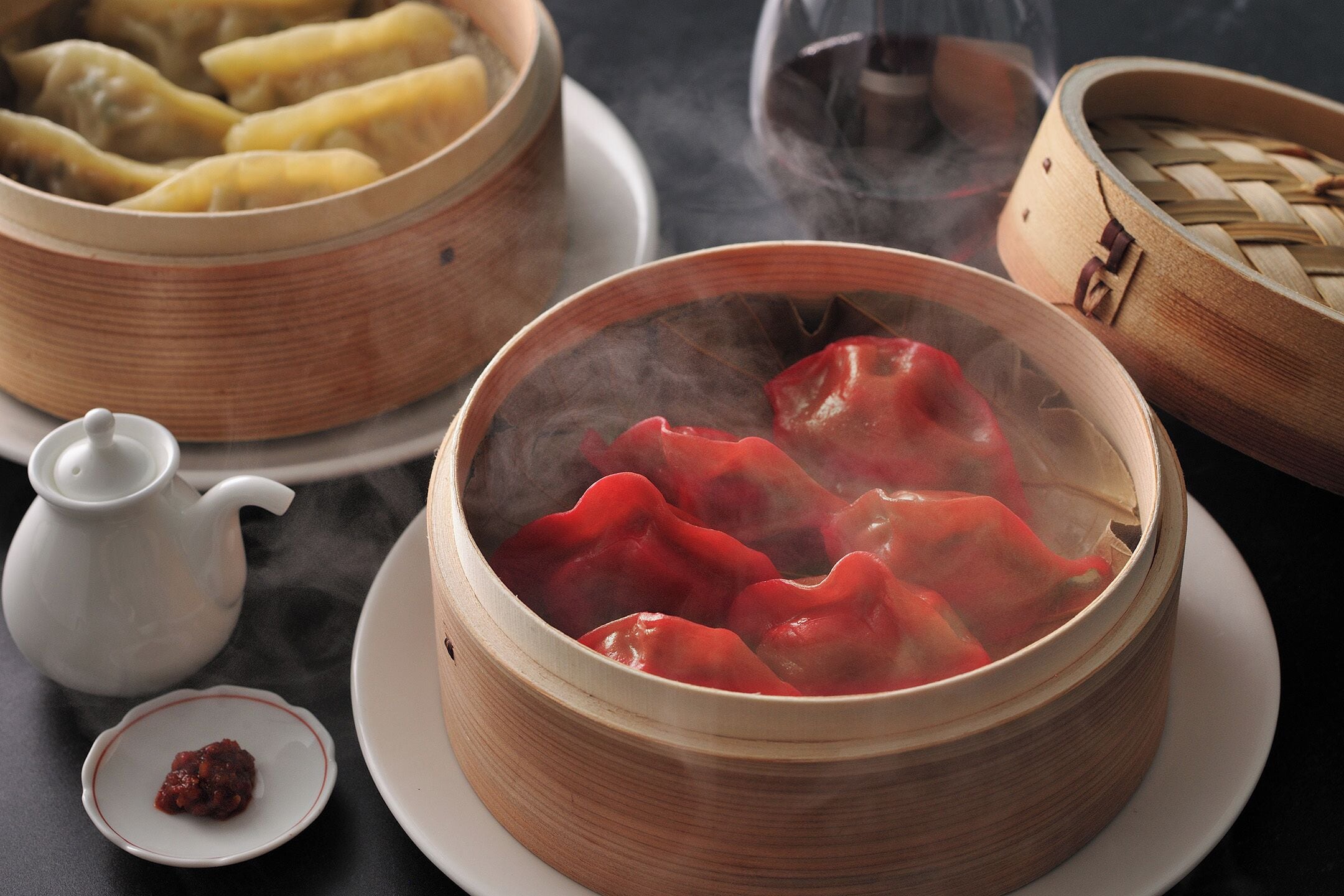 Vaporiera de bambu tradicional com dumplings e uma pequena chaleira.
