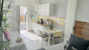 Espaço compacto com cozinha compacta, área de refeições e sala de estar com cama.