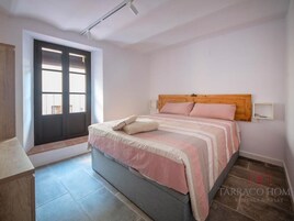 Quarto com uma cama, janela e porta.