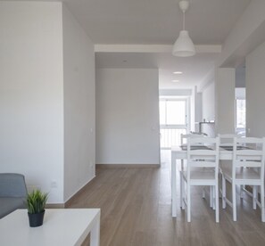 Uma sala de estar moderna e minimalista com uma área de jantar.