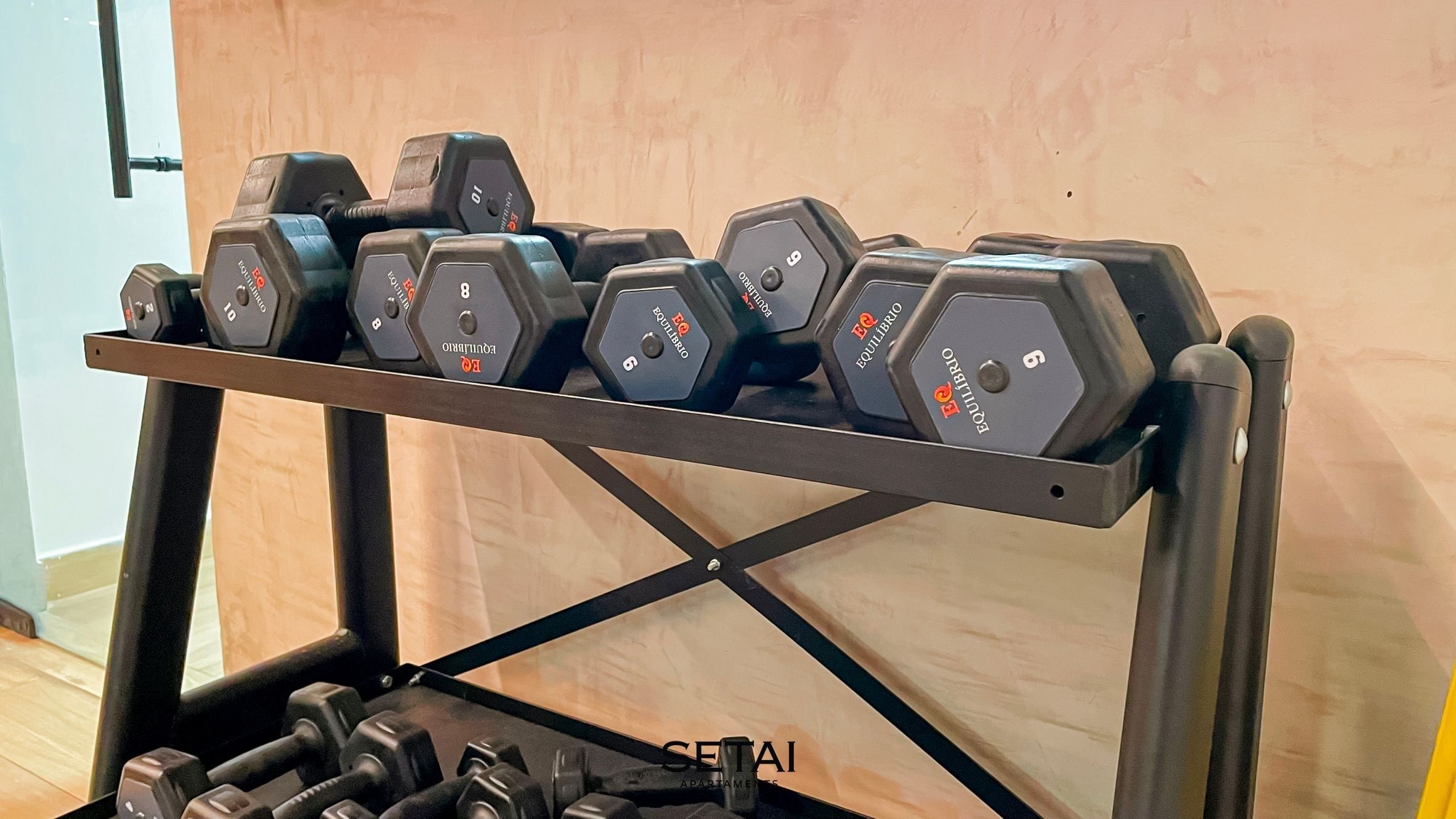 Um banco de musculação com halteres ajustáveis.