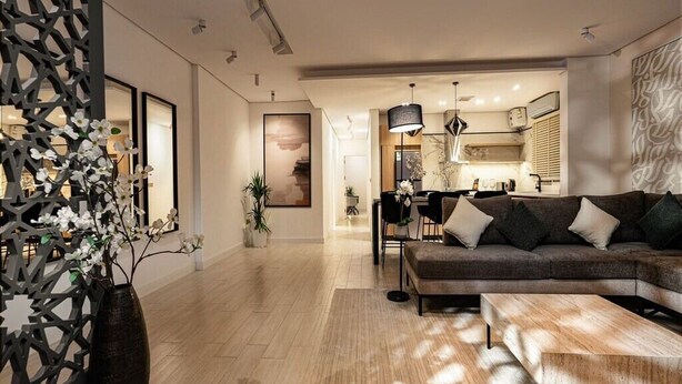 Uma sala de estar moderna com sofá, mesa de centro e plantas decorativas.