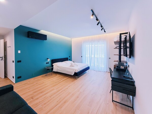 Quarto Duplo de Luxo, vista parcial para o mar | Cofre com capacidade para portátil, secretária, ferro/tábua de engomar