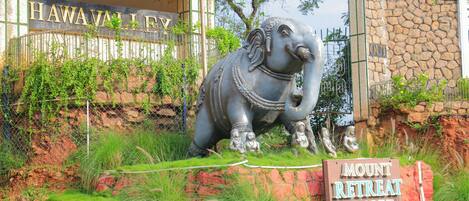 Uma estátua de elefante em frente a um edifício com a placa "HAWALLEY" e uma placa indicando "MOUNT RETREAT RESORT".