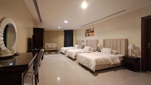 Quarto de hotel com duas camas, uma escrivaninha, uma cadeira, uma televisão e um quadro na parede.