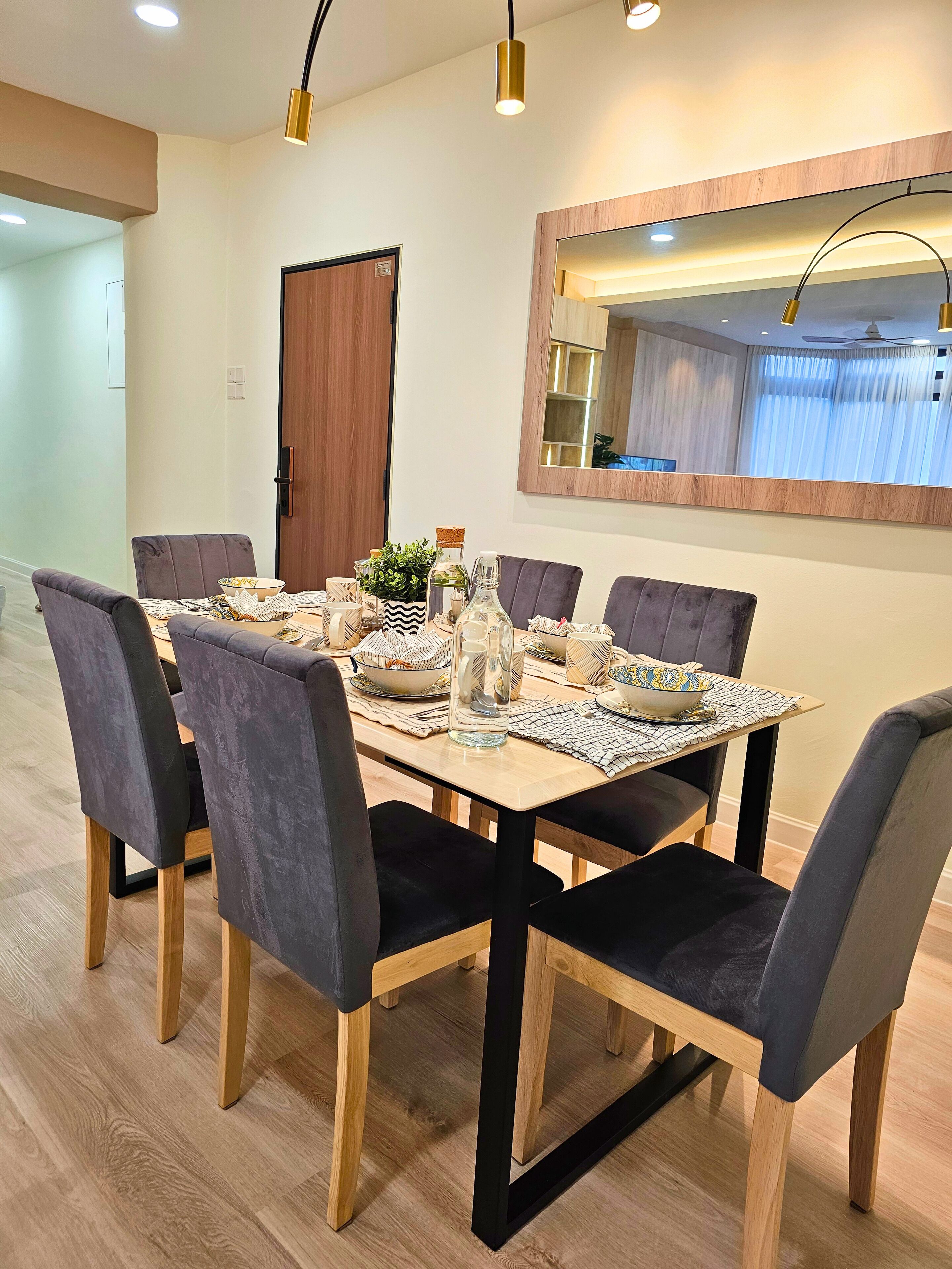 Uma sala de jantar moderna com uma mesa retangular, seis cadeiras e piso de madeira.
