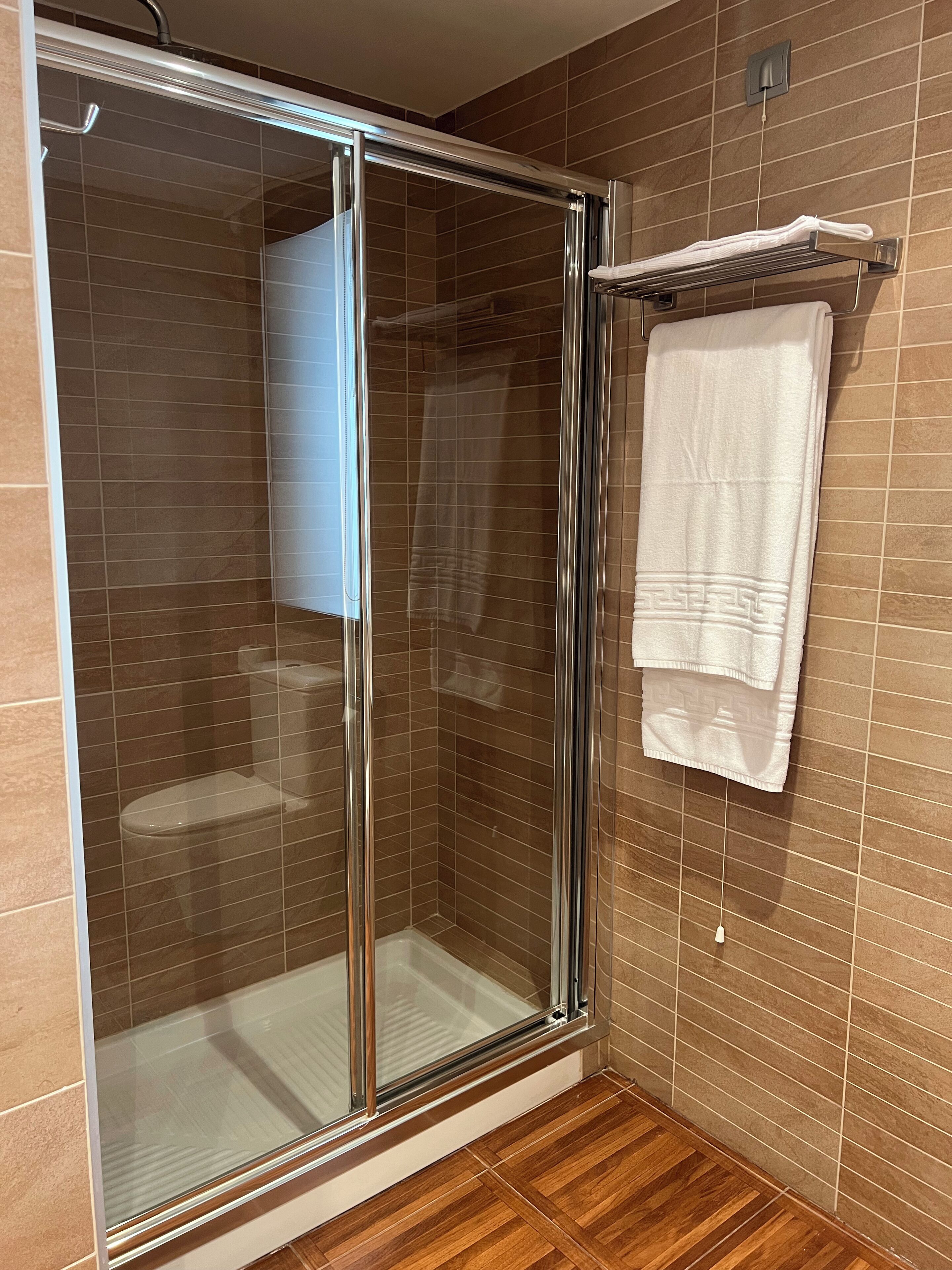 Box de vidro com toalha branca em um porta-toalhas.