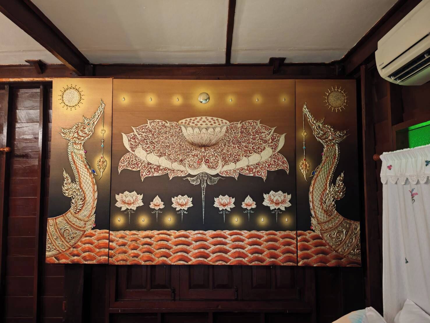 Um quarto com um amplo painel decorativo com motivos de flor de lótus e dragão.