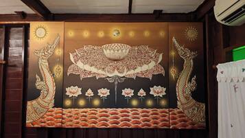 Um quarto com um amplo painel decorativo com motivos de flor de lótus e dragão.