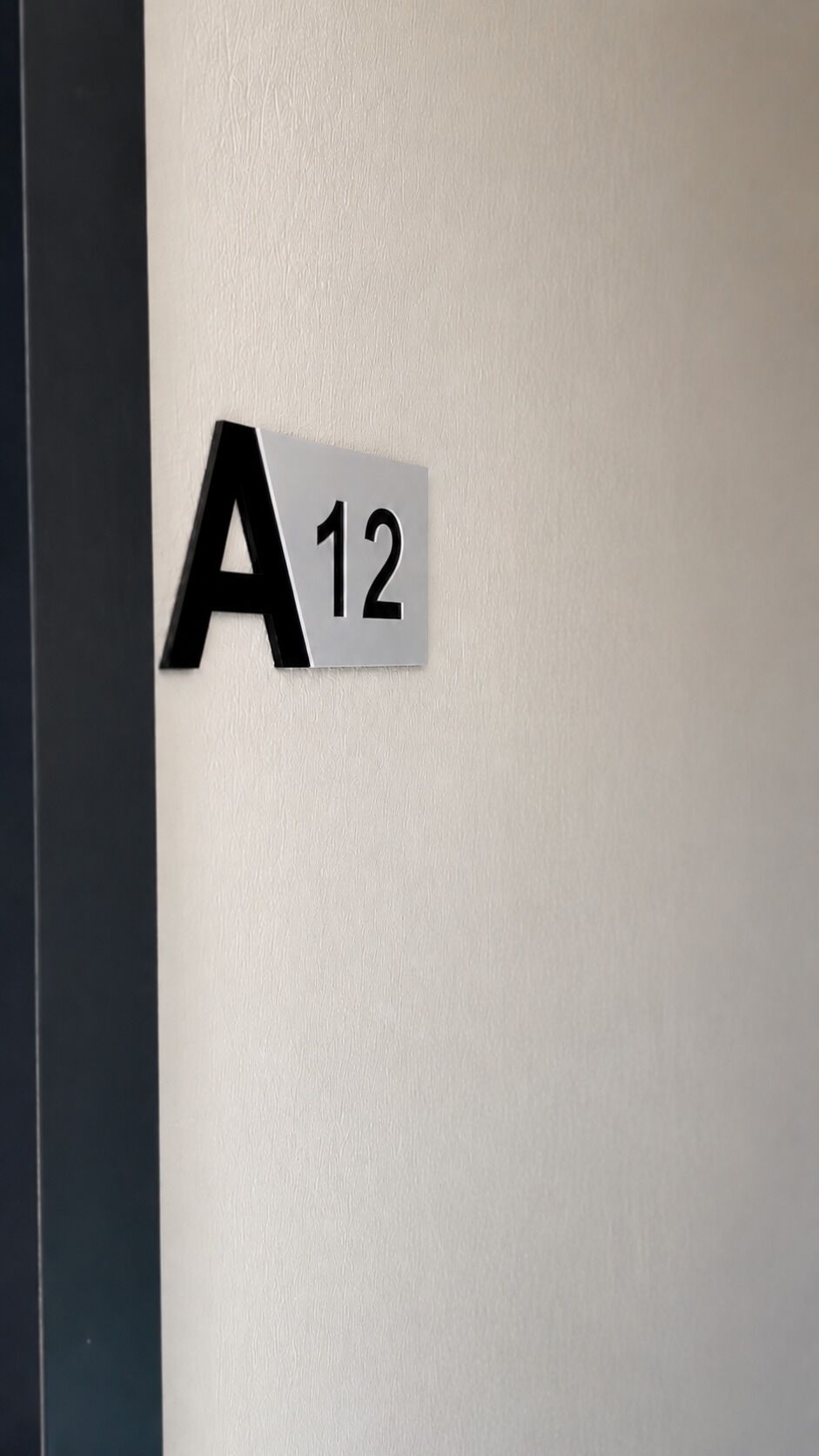 Paredes com uma placa indicando o quarto A12.