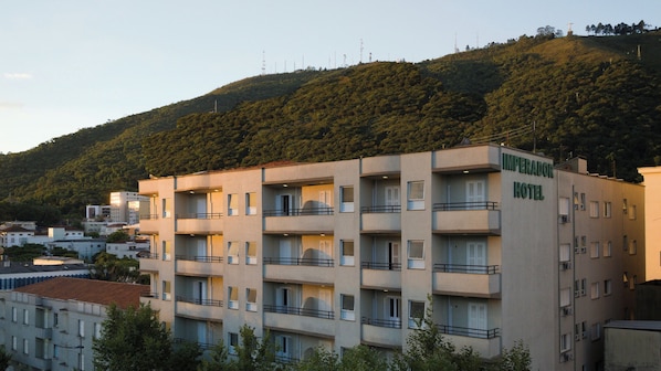 Um hotel de vários andares com varandas e uma placa com a inscrição "IMPERADOR HOTEL".