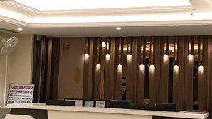Uma receção com design moderno, uma placa informativa e um teto com iluminação embutida.