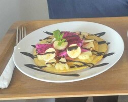 Prato de comida sobre uma mesa de madeira, com um garfo à esquerda.