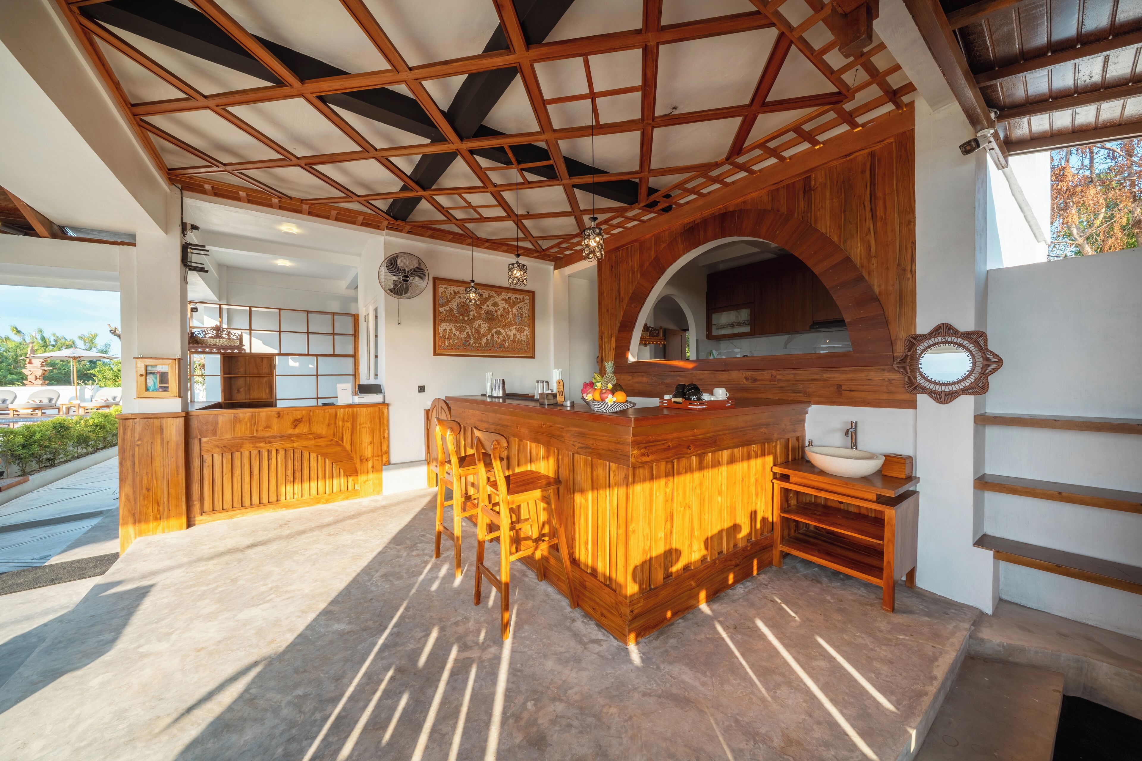 Uma cozinha espaçosa com balcão de madeira e área de estar, um espelho grande e vista para o exterior.