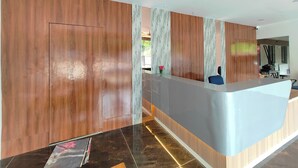 Uma área de recepção moderna com balcão de madeira e uma cadeira azul.