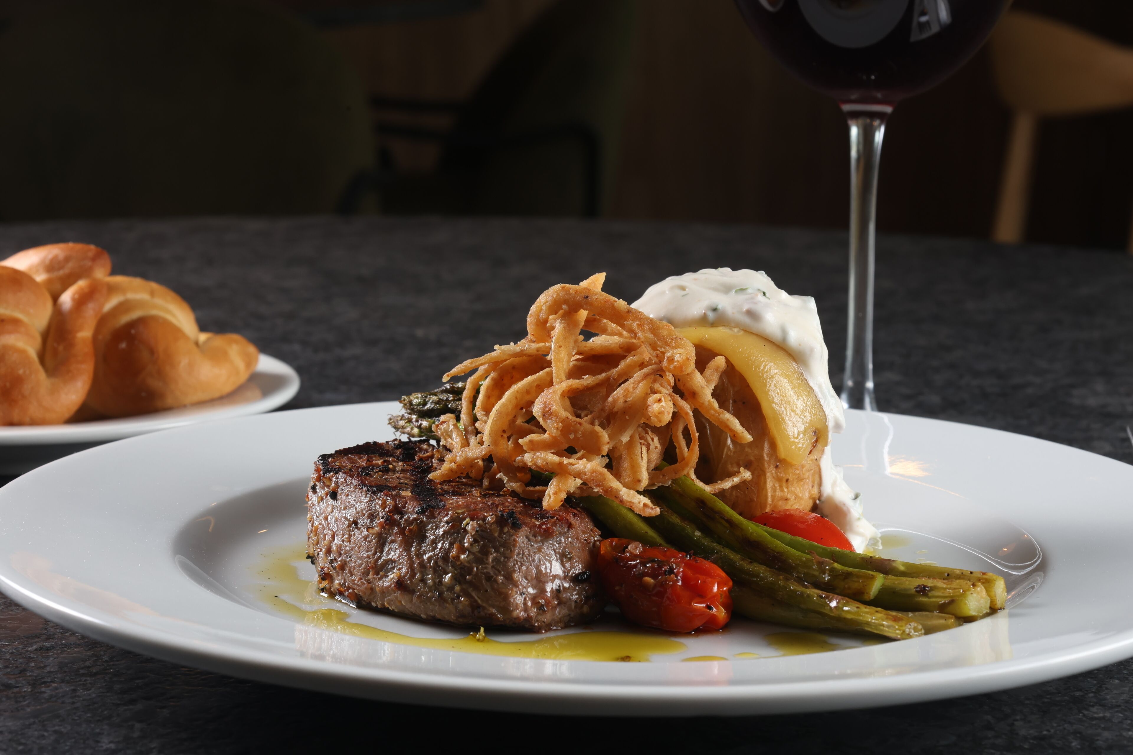 Prato com bife, aspargos e molho.