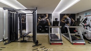 Uma academia com equipamentos de ginástica, esteiras e uma parede com pôsteres motivacionais.