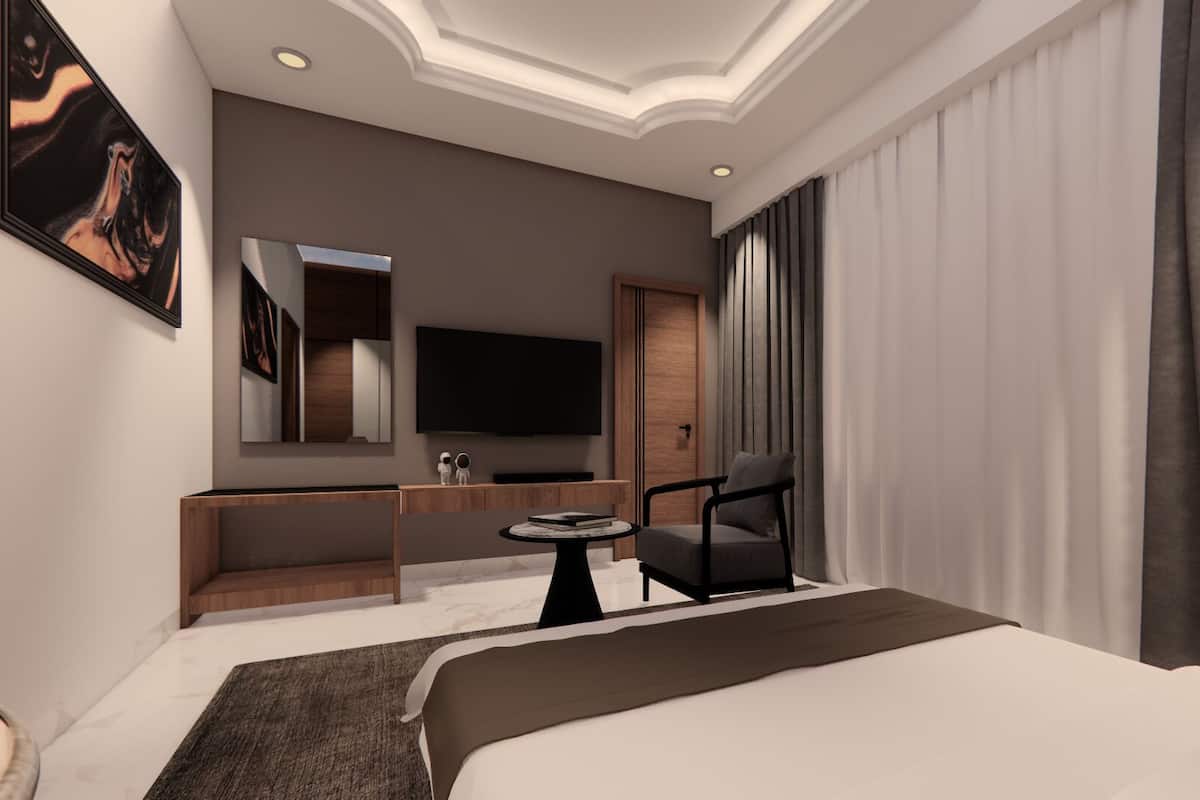 Quarto de hotel moderno com uma cama grande, uma mesa com cadeira, TV de tela plana e uma janela ampla com cortinas.