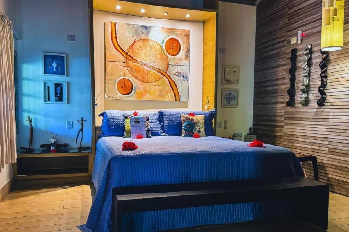 Um quarto moderno com uma cama grande, uma parede de madeira e uma pintura sobre a cama.