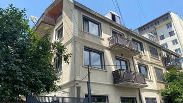 Um edifício com várias andares, varandas e janelas amplas.