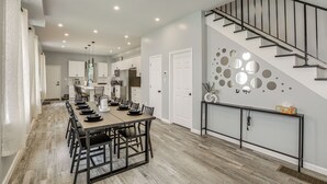 Cozinha moderna com área de jantar, escada e corredor com detalhe decorativo.