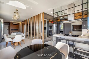 Cozinha moderna com ilha central, eletrodomésticos embutidos e um mezanino.