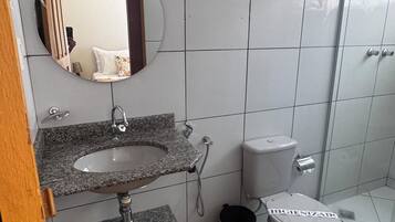 Casa de banho com lavatório de granito, sanita, bidé e zona de duche.