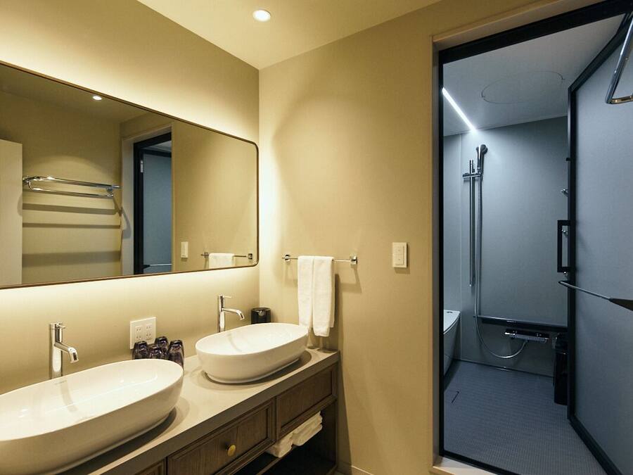 Uma casa de banho moderna com duas pias, um espelho grande e uma área de duche.
