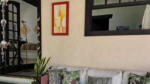 Uma sala de estar aconchegante com um sofá, uma mesa de centro e uma planta em vaso.