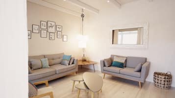 Suite Deluxe, pátio, vista para o mar | Sala de estar | Televisor de ecrã plano de 40 polegadas com canais digitais
