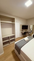 Quarto com cama, escrivaninha, cadeira e guarda-roupa.