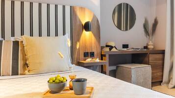 Quarto de hotel moderno com cama, mesa de cabeceira e escrivaninha com cadeira.