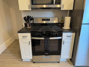 Um frigorífico/congelador grande, um micro-ondas, um forno