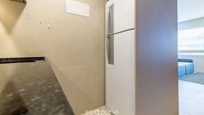 Casa de banho moderna com chuveiro, sanita e lavatório. Uma porta dá acesso a uma varanda com vista.