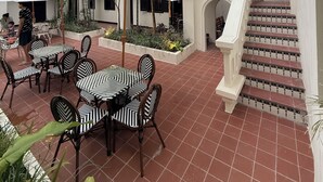 Pátio com área de estar externa, escadas e vista da arquitetura do edifício.