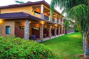 Um hotel com vários andares, fachada de pedra, varandas e áreas de estar ao ar livre.