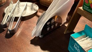 Disposição de buffet com pão, utensílios e guardanapos.